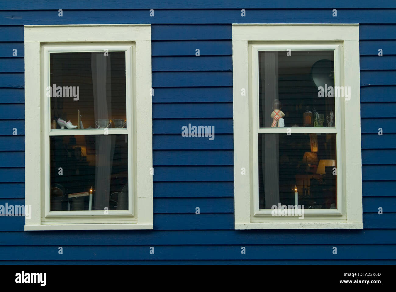 Pair of creme color windows on blue wall Stock Photo - Alamy