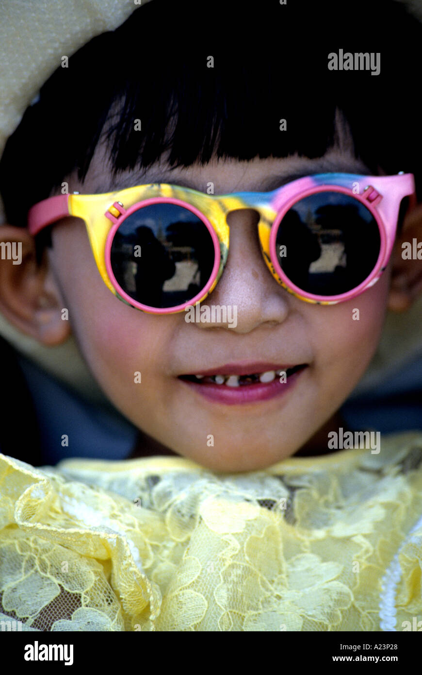 Burmese girl in bright colouful sunglasses and Tanaka bark paste on her ...