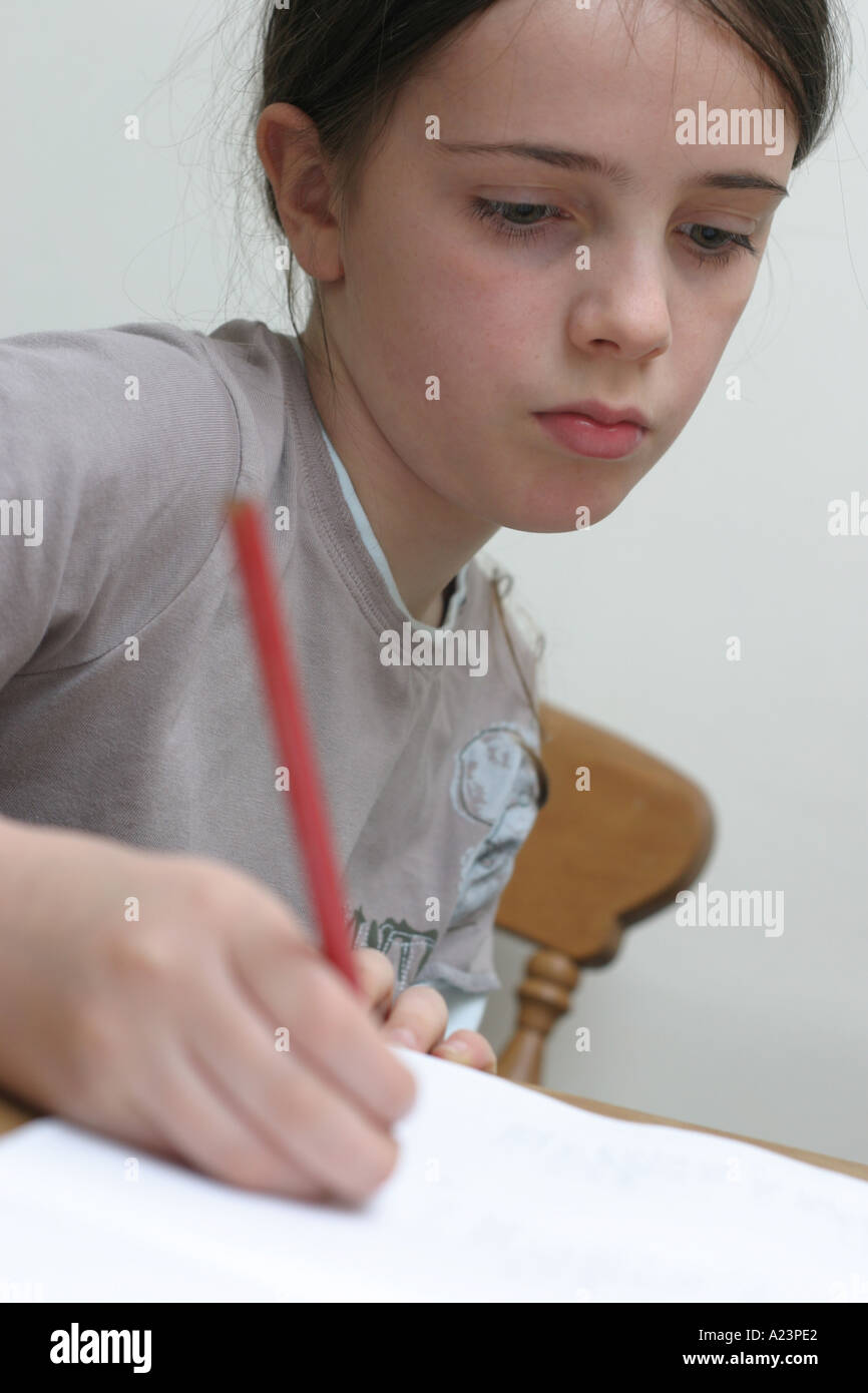 9 year old girl sitting at table doing her maths homework Stock Photo ...