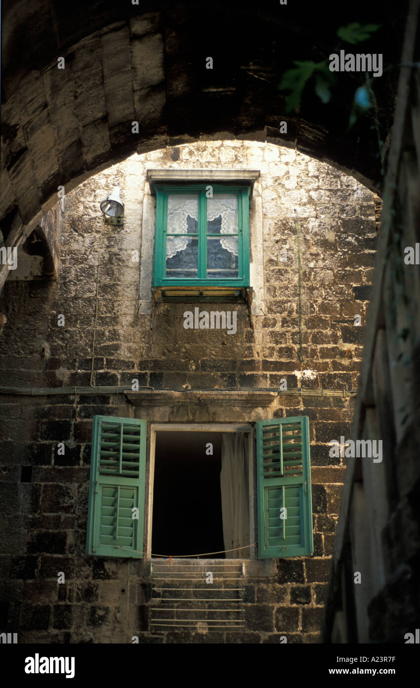 Green windows on an old stone house seen through an arch Split Croatia ...