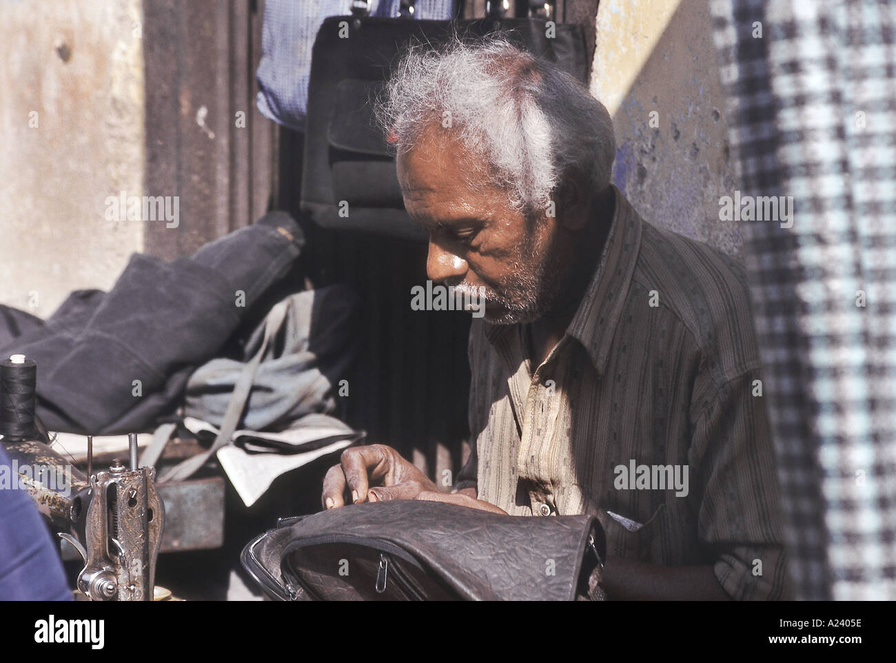 An old man making leather bags Stock Photo - Alamy