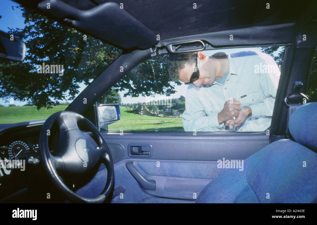 Man breaking in to car Stock Photo - Alamy