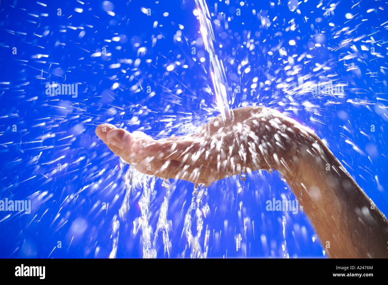 Hands splashed with running water against blue background Stock Photo ...