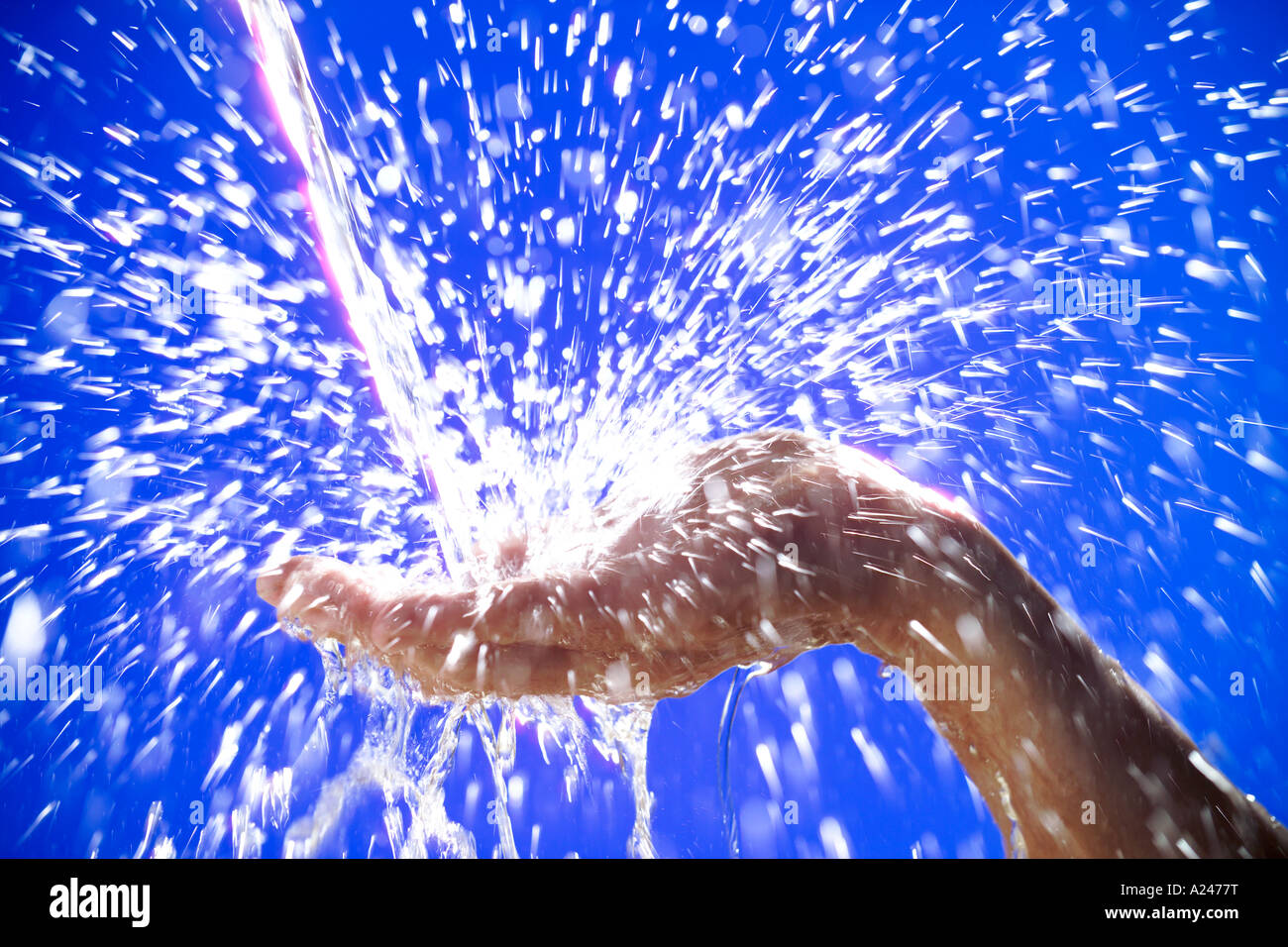 Hands splashed with running water against blue background Stock Photo ...