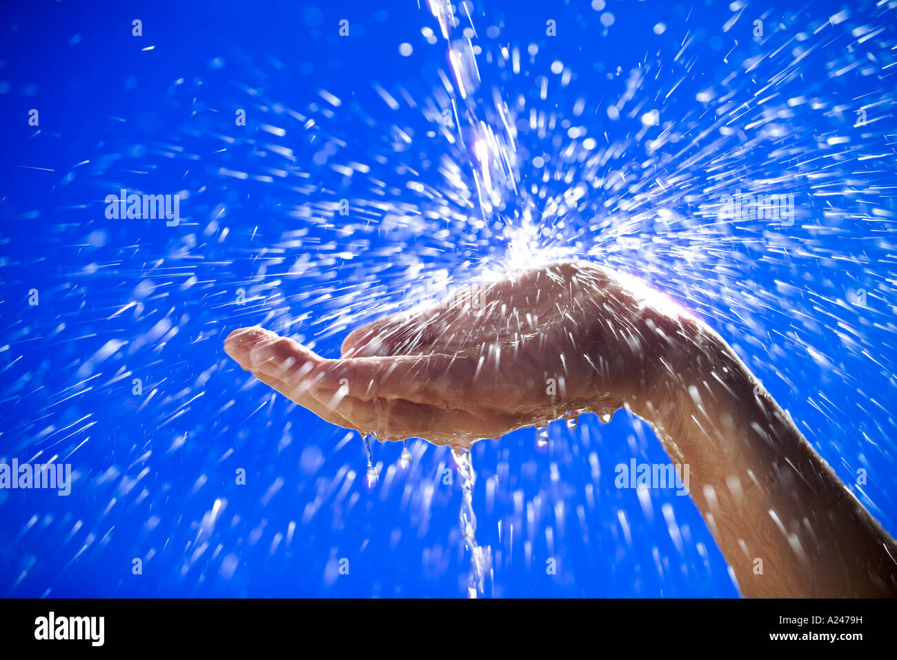 Hands splashed with running water against blue background Stock Photo ...