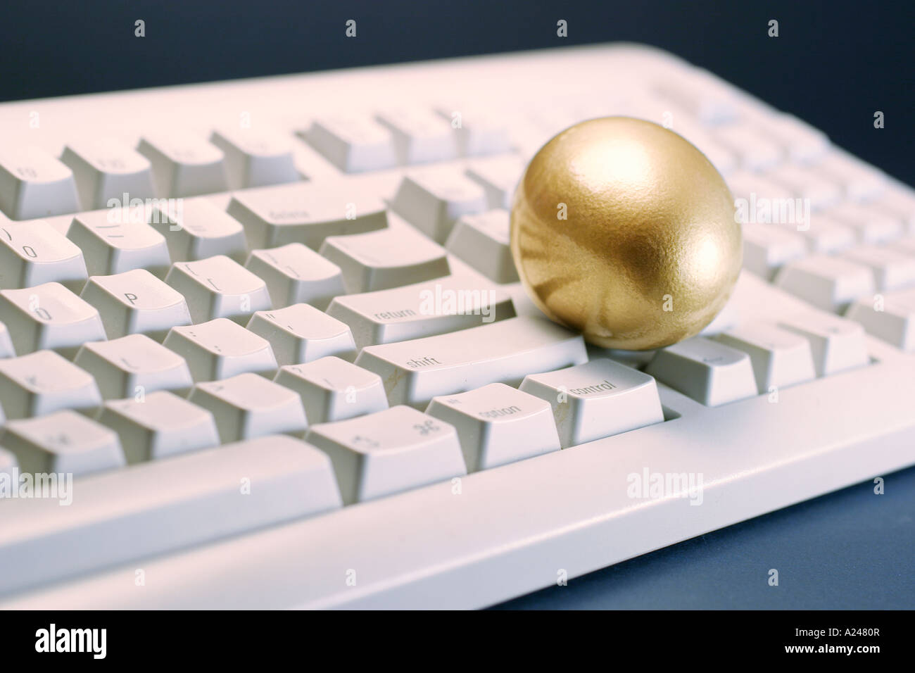 Golden Egg on Computer Keyboard Stock Photo - Alamy