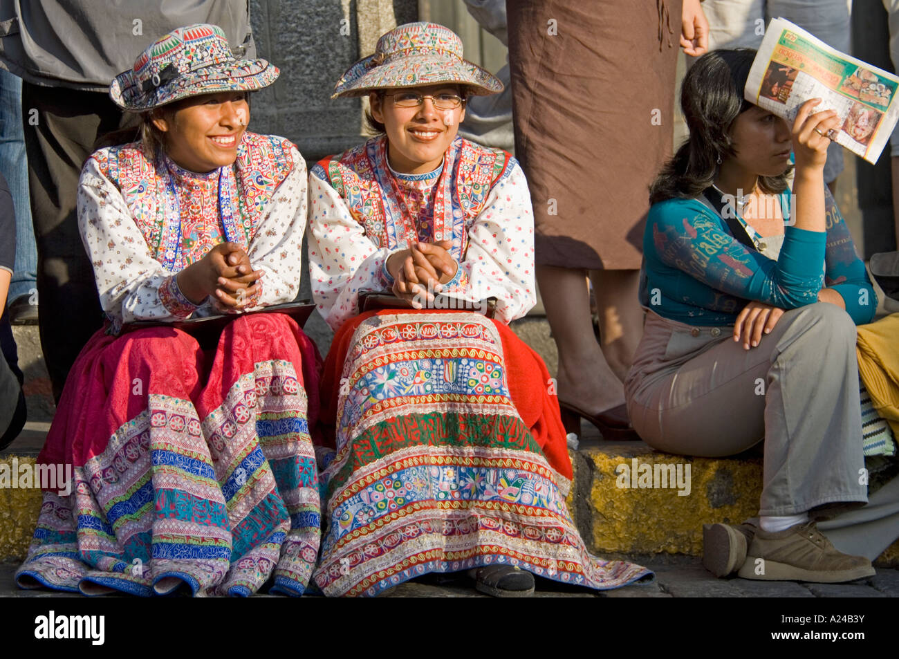 2 local women in traditional dress watching one of the many street ...