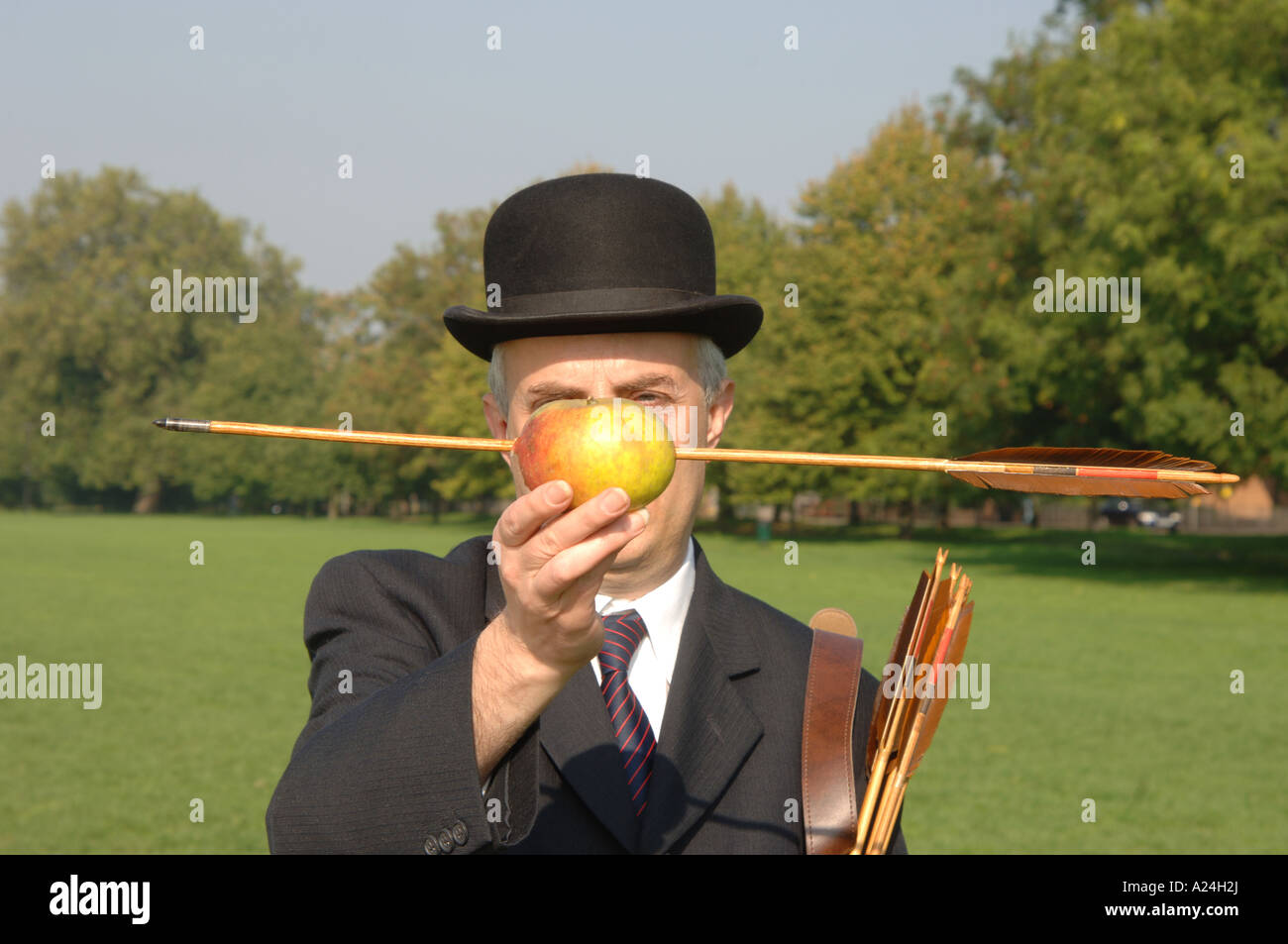 Apple with arrow through it and man in bowler hat Stock Photo - Alamy