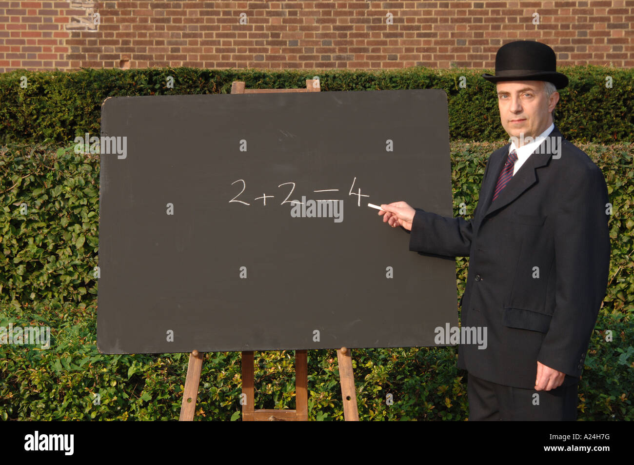 City gent in suit and bowler hat explaining simple maths with ...