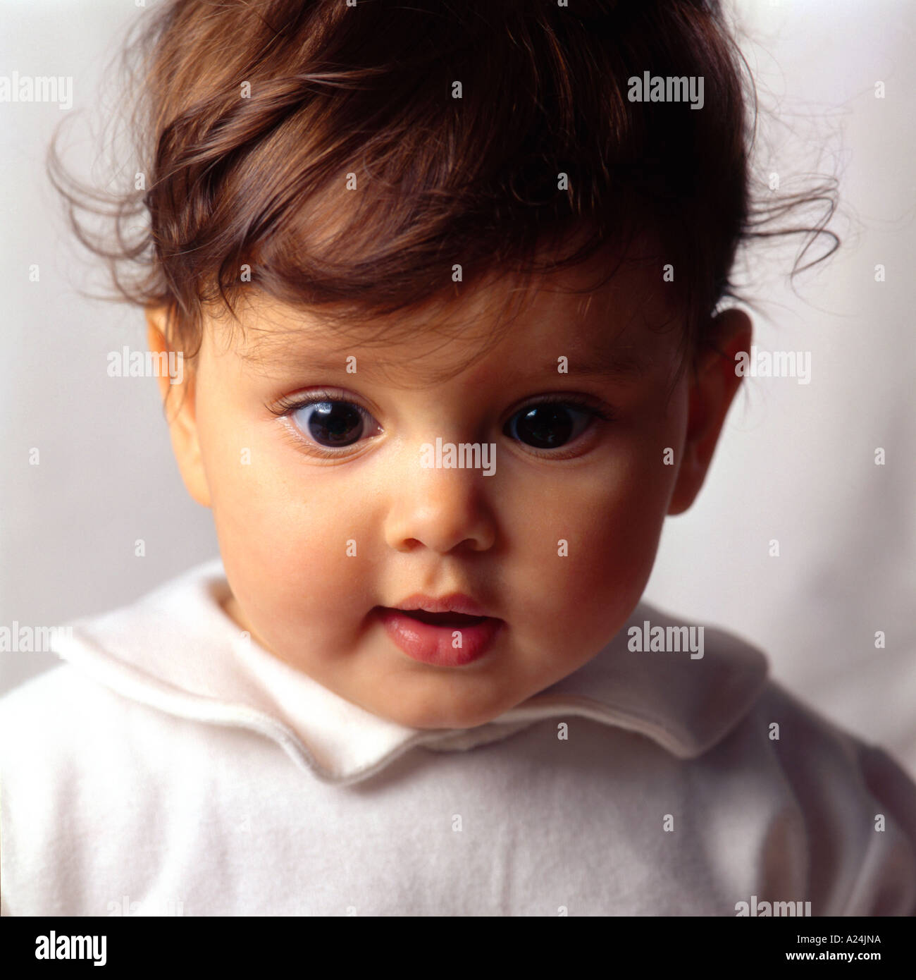 Little baby girl looking down at some point in front of her Stock Photo ...