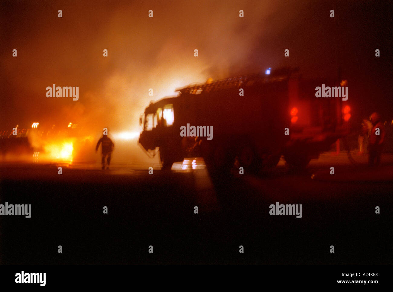 A fire engine and firemen attend to a burning aircraft during a ...