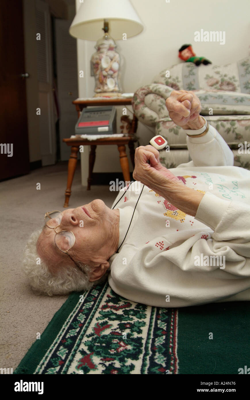 Senior female uses a medical alert alarm system for emergency call for ...