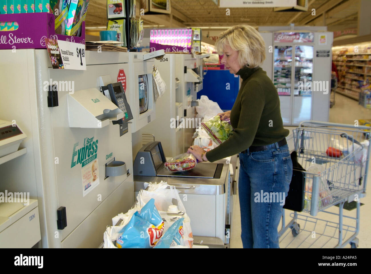 Female uses self serve check out in a modern grocery super store Stock ...