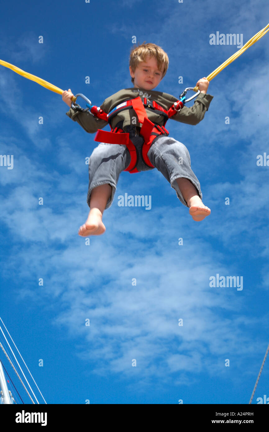 young child bouncing on bungee trampoline gymnastic apparatus against ...