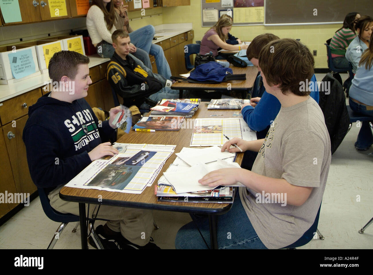 Male students interact in a group project in high school class room ...