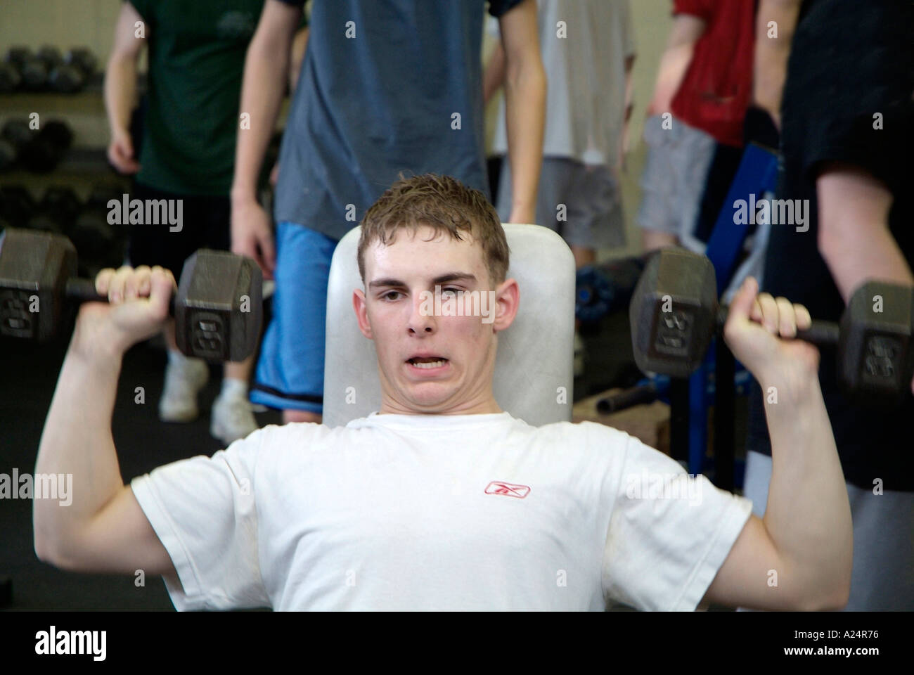Students work out in a weight training room in a high school class ...