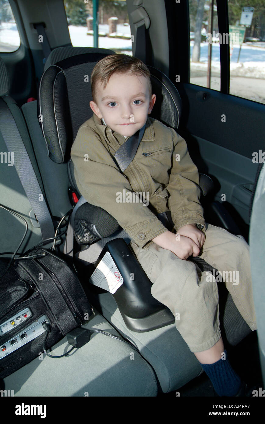 Boy sits in the back seat of automobile in a child seat Stock Photo - Alamy
