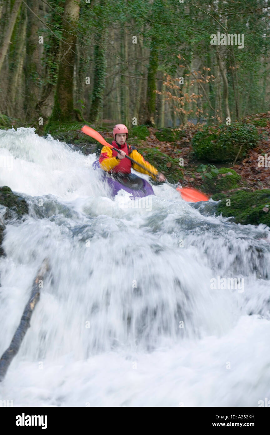 A canoeist running a waterfall in flood on the outskirts of windermere ...