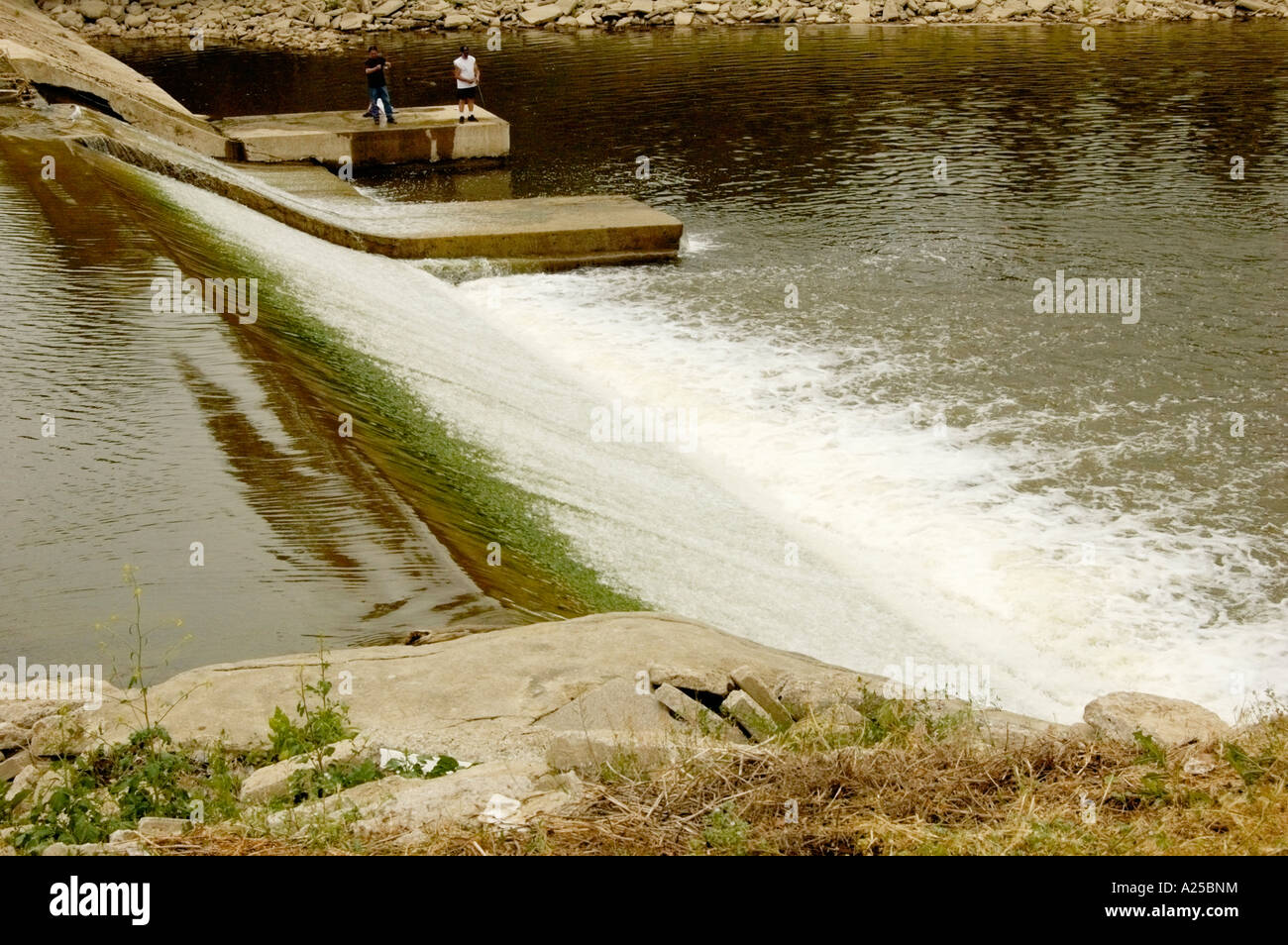 Two guys fishing below the dam Stock Photo - Alamy
