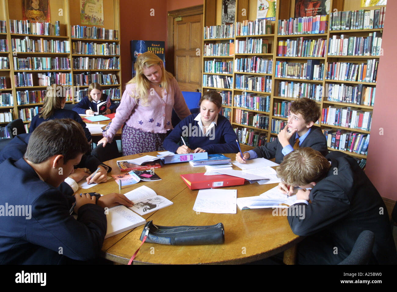 O level students working in the library with teacher supervising Stock ...