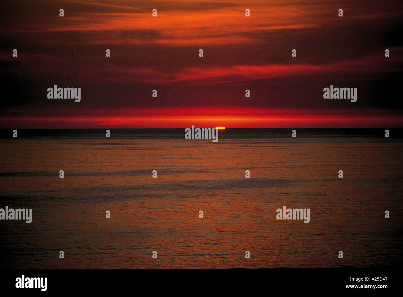 SUN SETTING BELOW THE HORIZON Stock Photo - Alamy