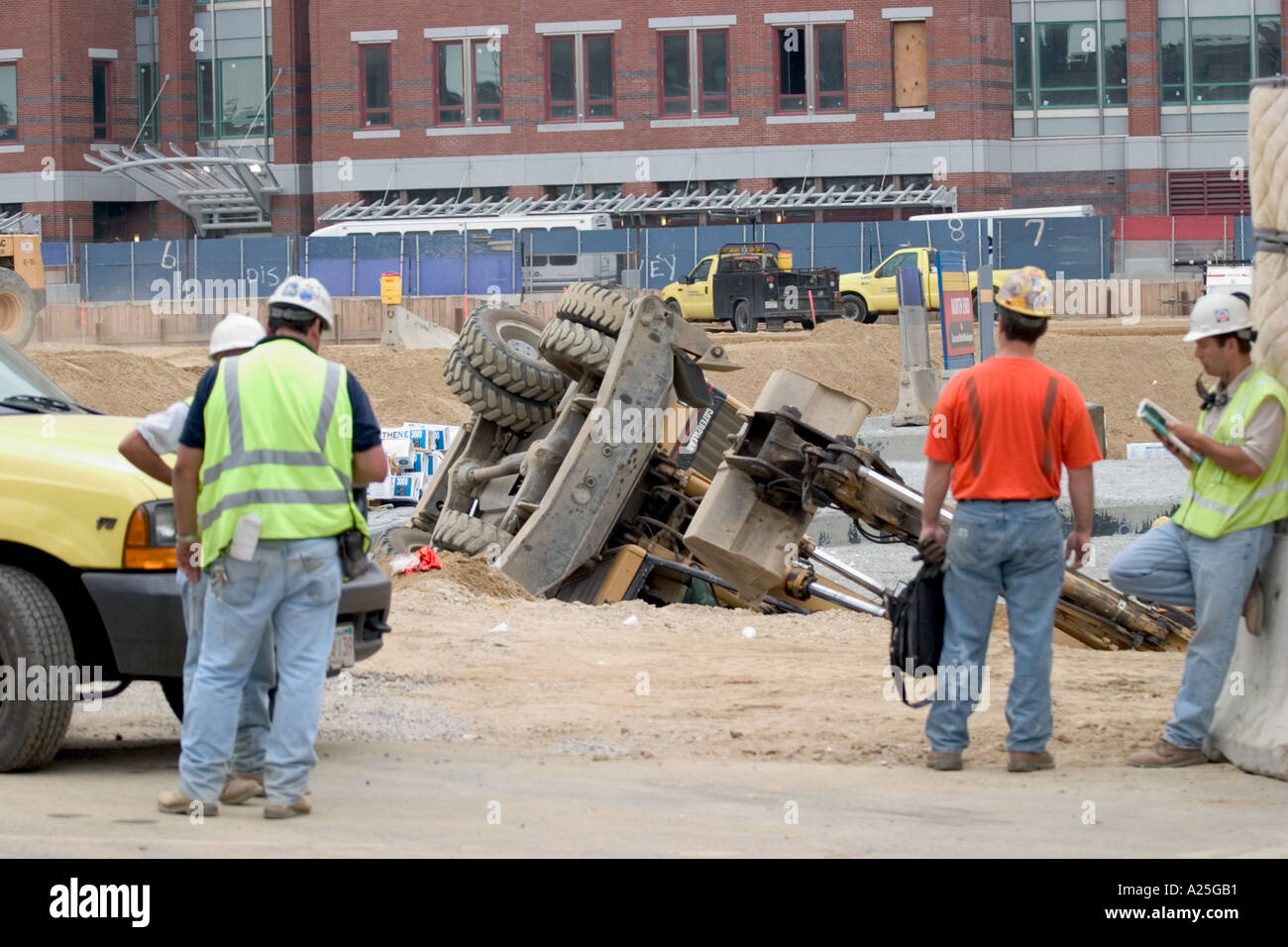 Workers looking at an overturned truck at a city construction site ...