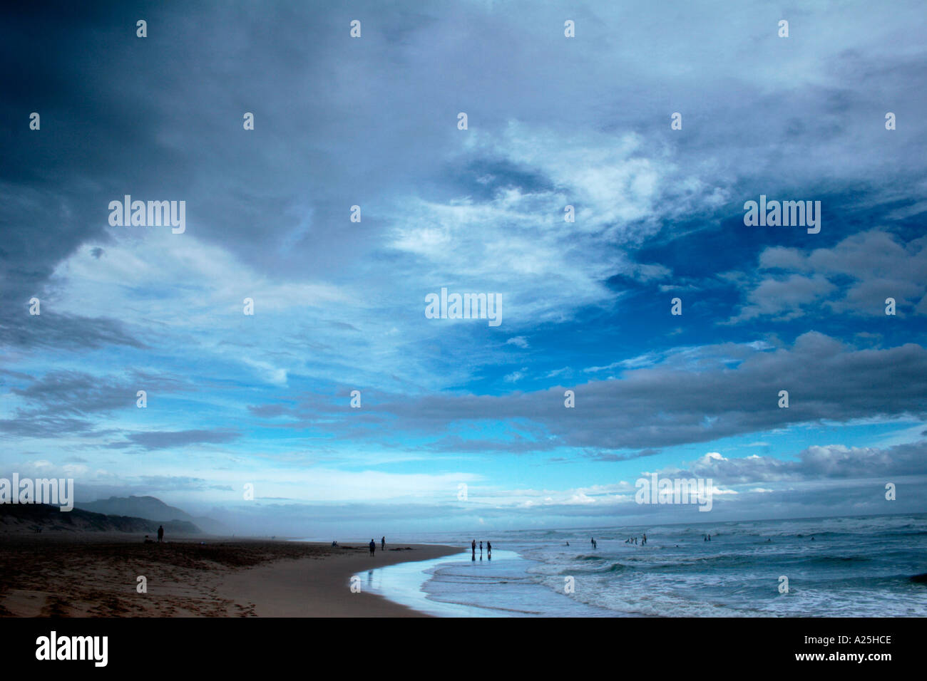 People swimming in sea as thunder storm clouds come in extreme weather ...