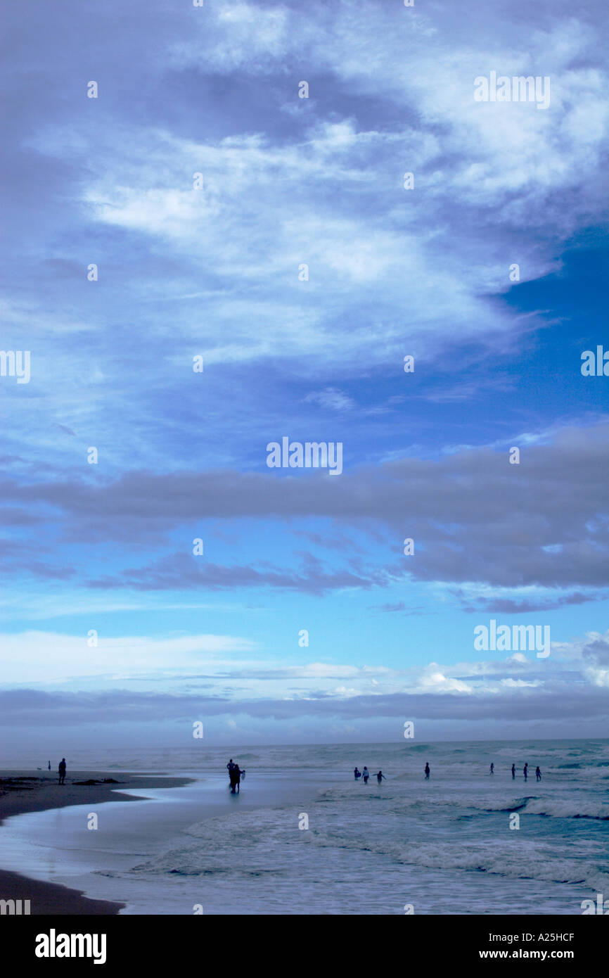 People swimming in sea as thunder storm clouds come in extreme weather ...