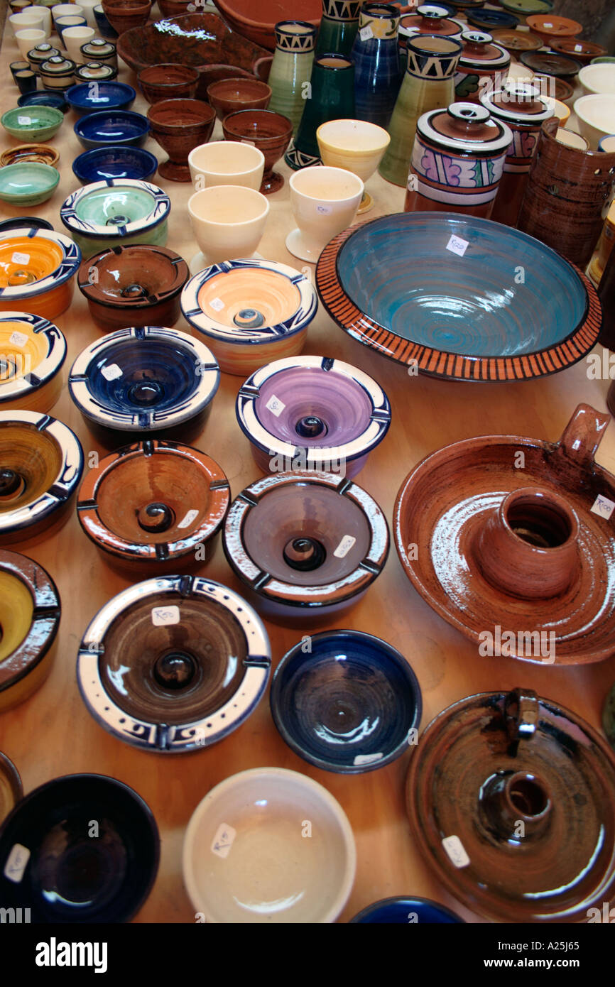 Bright coloured colored glazed pottery on display table Stock Photo - Alamy