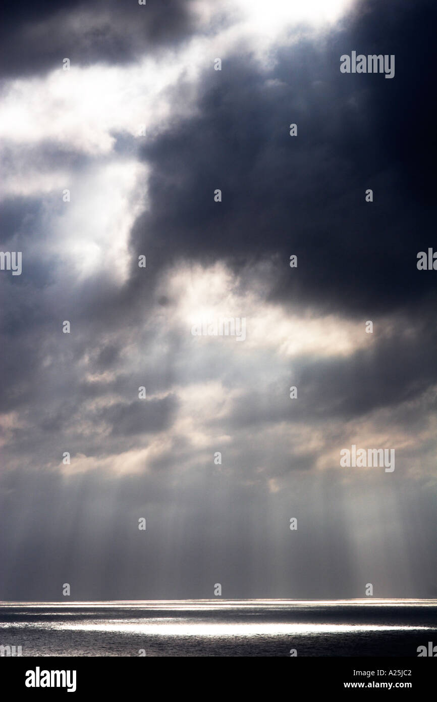 Shafts beams of sunlight coming through clouds out to sea Stock Photo ...