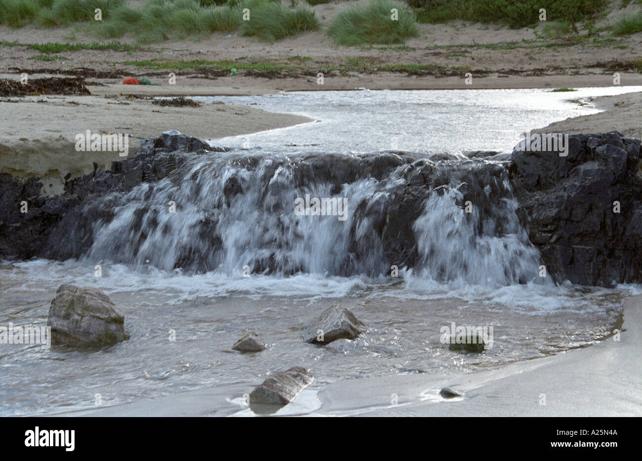 Water falling over rocks on Beach Stock Photo - Alamy