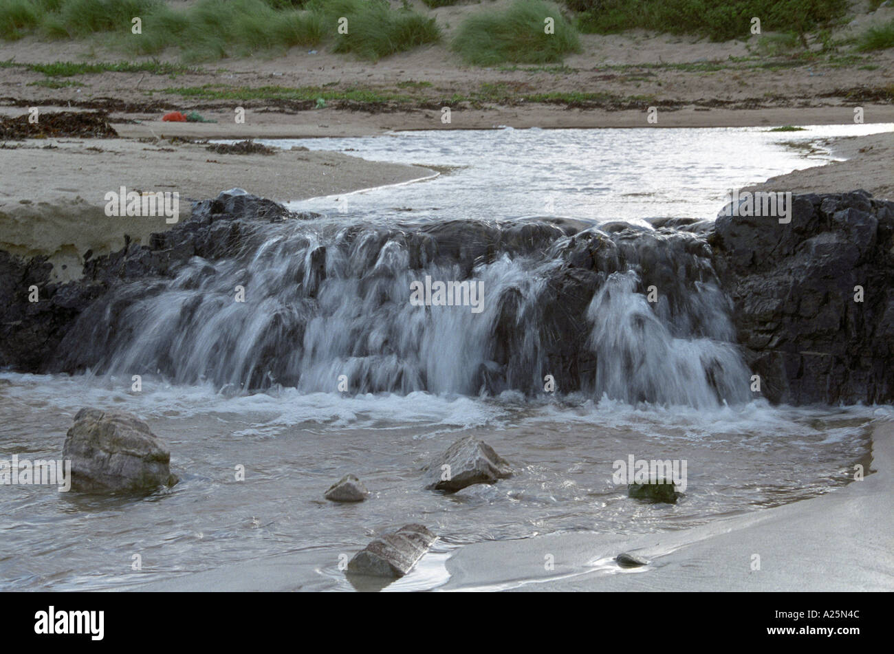 Water flowing over rocks on Beach Stock Photo - Alamy