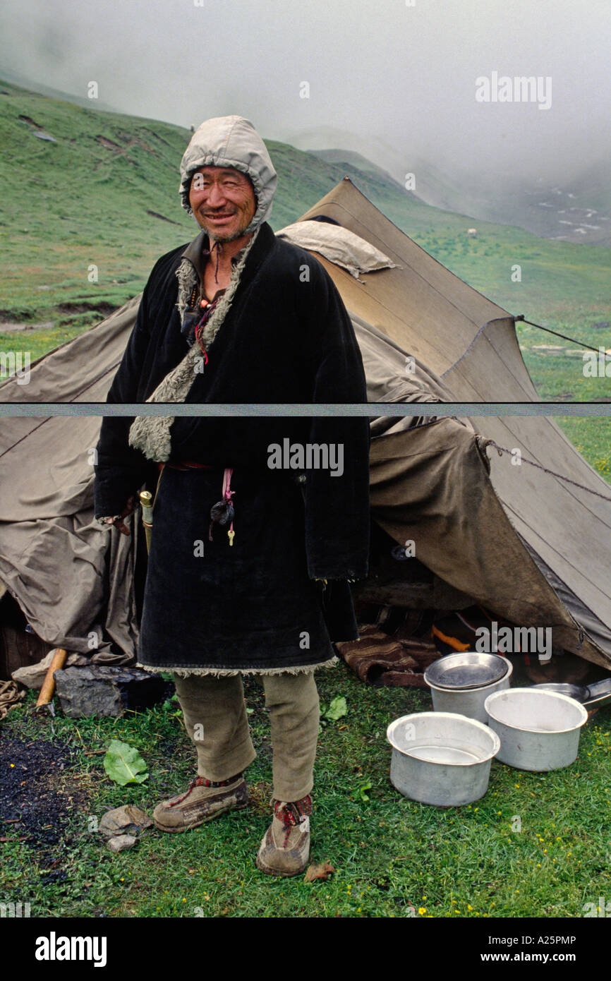 TIBETAN DROKPA or nomadic YAK HERDER stands in front of his traditional ...