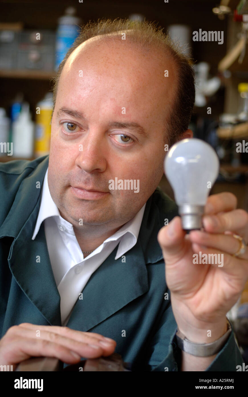 AN ELECTRICAL SHOP OWNER IN HIS WORKSHOP WITH A LIGHT BULB UK Stock ...