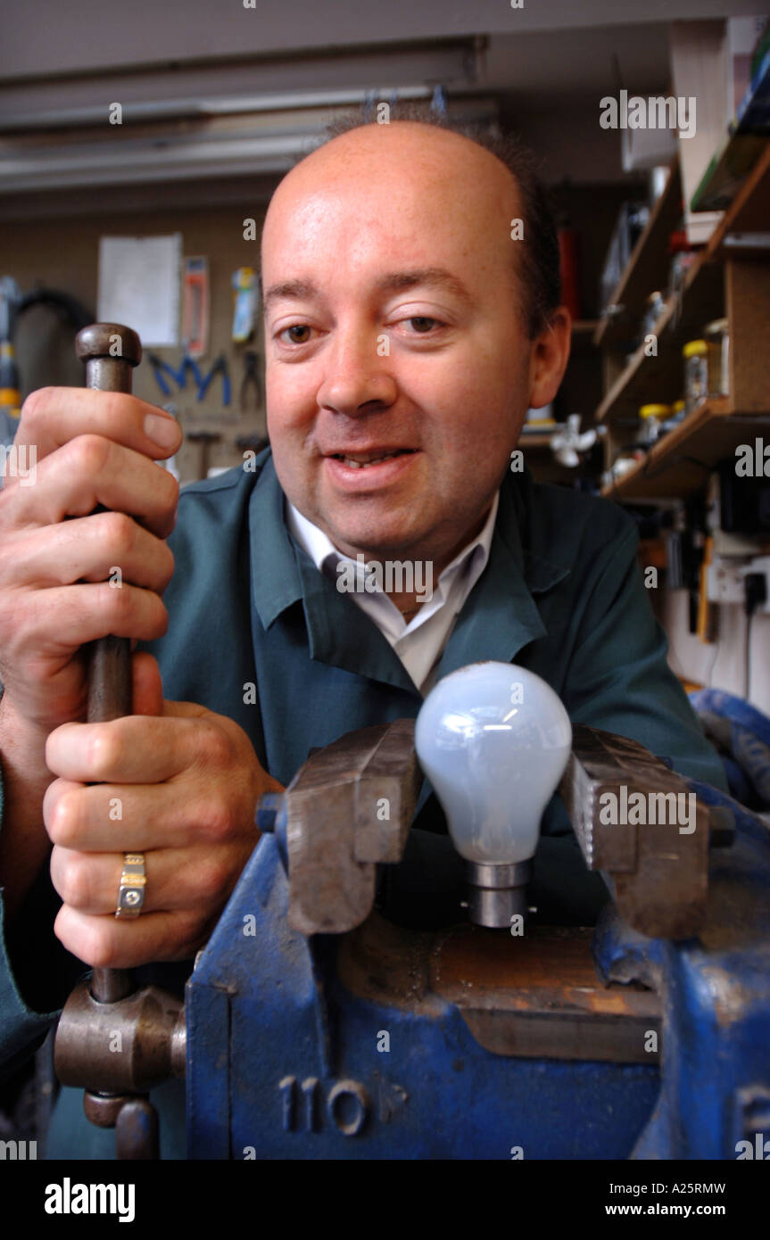 AN ELECTRICAL SHOP OWNER IN HIS WORKSHOP WITH A LIGHT BULB IN A VICE UK ...