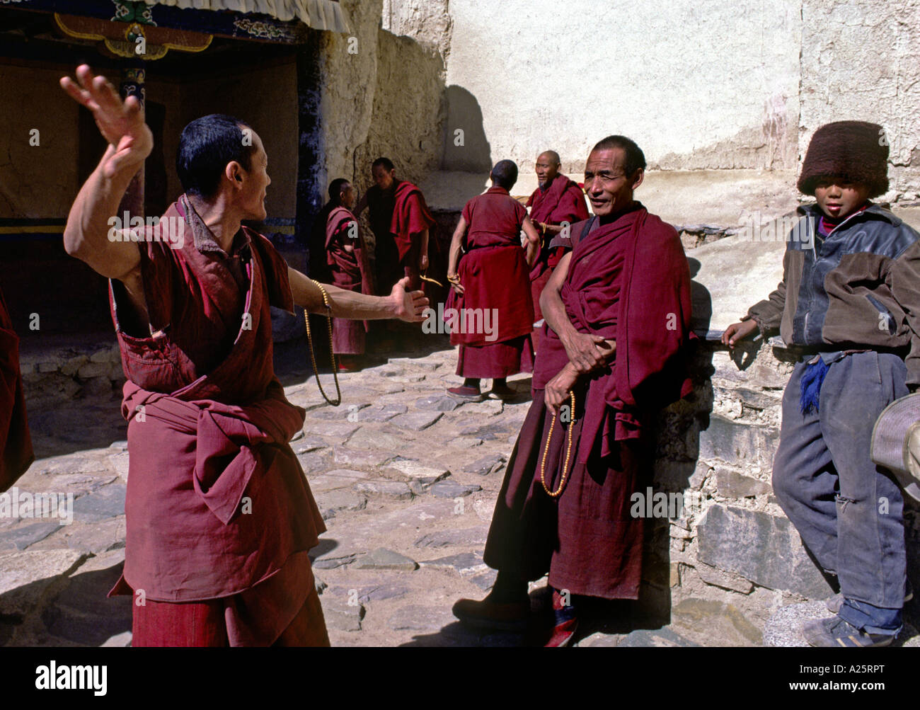 Monks practicing ritualized TIBETAN BUDDHIST debate at TASHILHUNPO ...