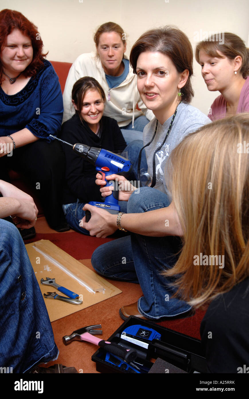 WOMEN WATCHING A DEMONSTRATION BY A FEMALE DIY EXPERT AT A TOOLS PARTY ...