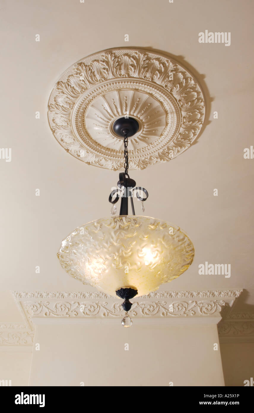 Glass and wrought iron CHANDELIER and elaborate ceiling molding in a ...