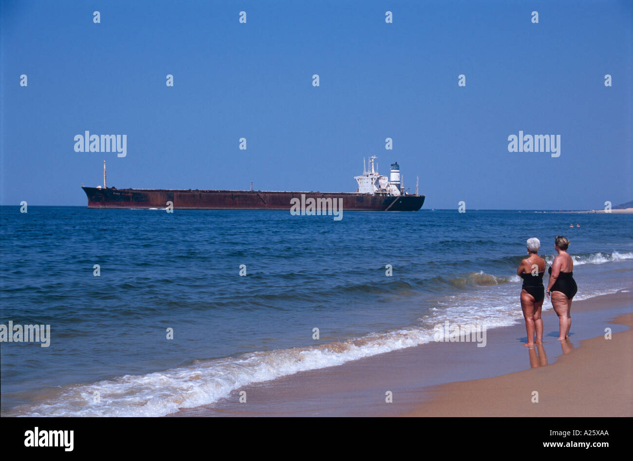 two obese women looking at stranded oil tanker on Candolim beach, Goa ...