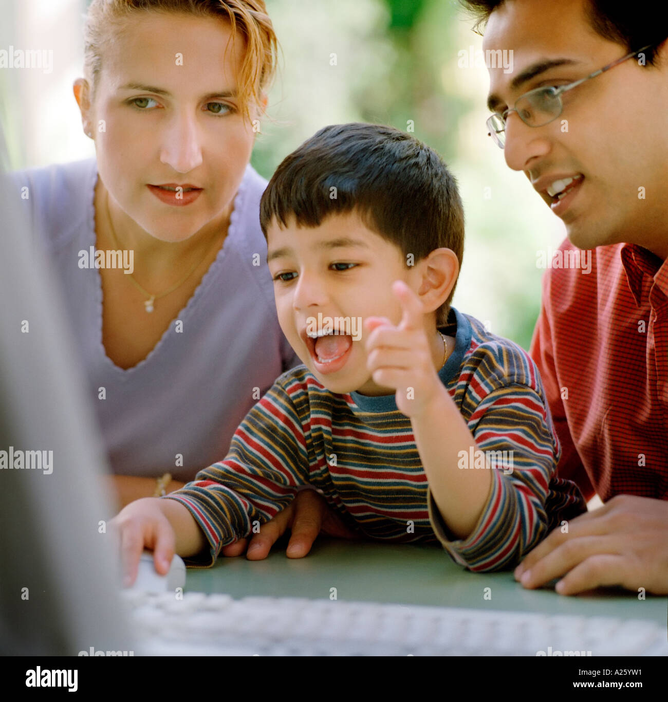 mixed race family sitting together at the computer, light airy ...
