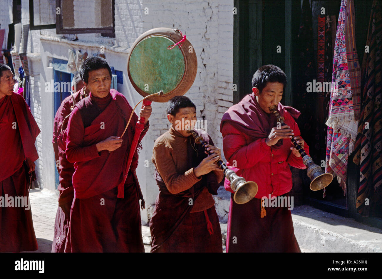 Tibetan Buddhist monks play musical instruments as they parade around ...