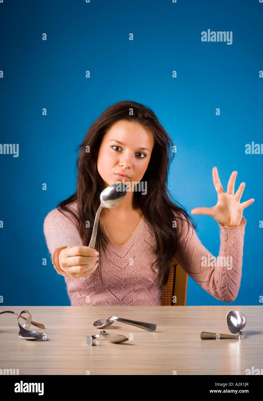 woman s bending spoon by mind force on the blue background Stock Photo ...
