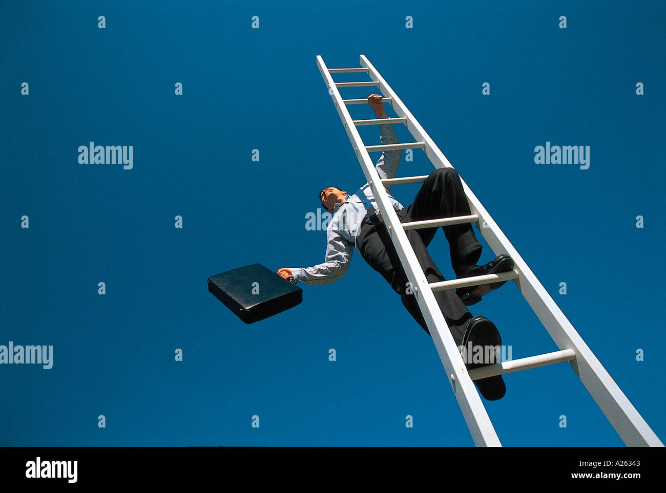 EXECUTIVE CLIMBING UP UNSUPPORTED LADDER Stock Photo - Alamy