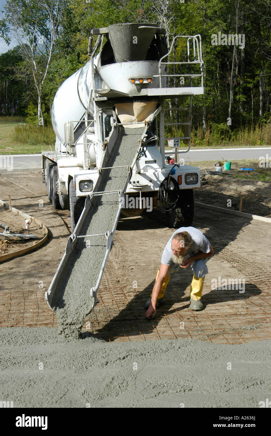 Mason cement workers pour driveway in a new home construction project ...