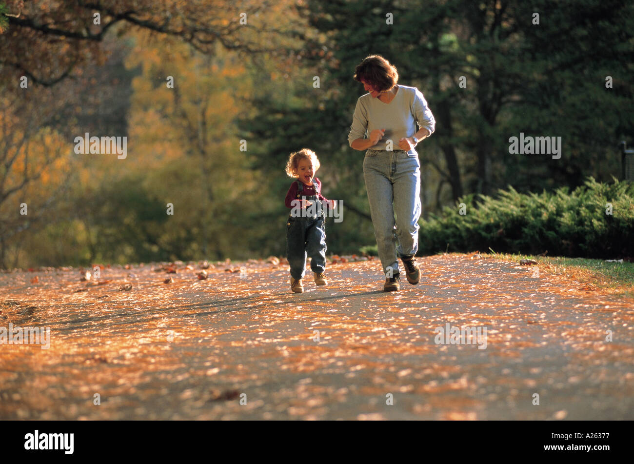 MOTHER AND HER YOUNG DAUGHTER RUNNING ALONG PATH Stock Photo - Alamy