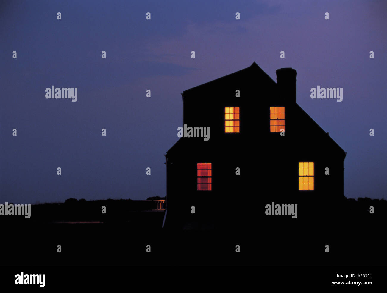 ILLUMINATED WINDOWS IN HOUSE SILHOUETTED AGAINST NIGHT SKY Stock Photo ...