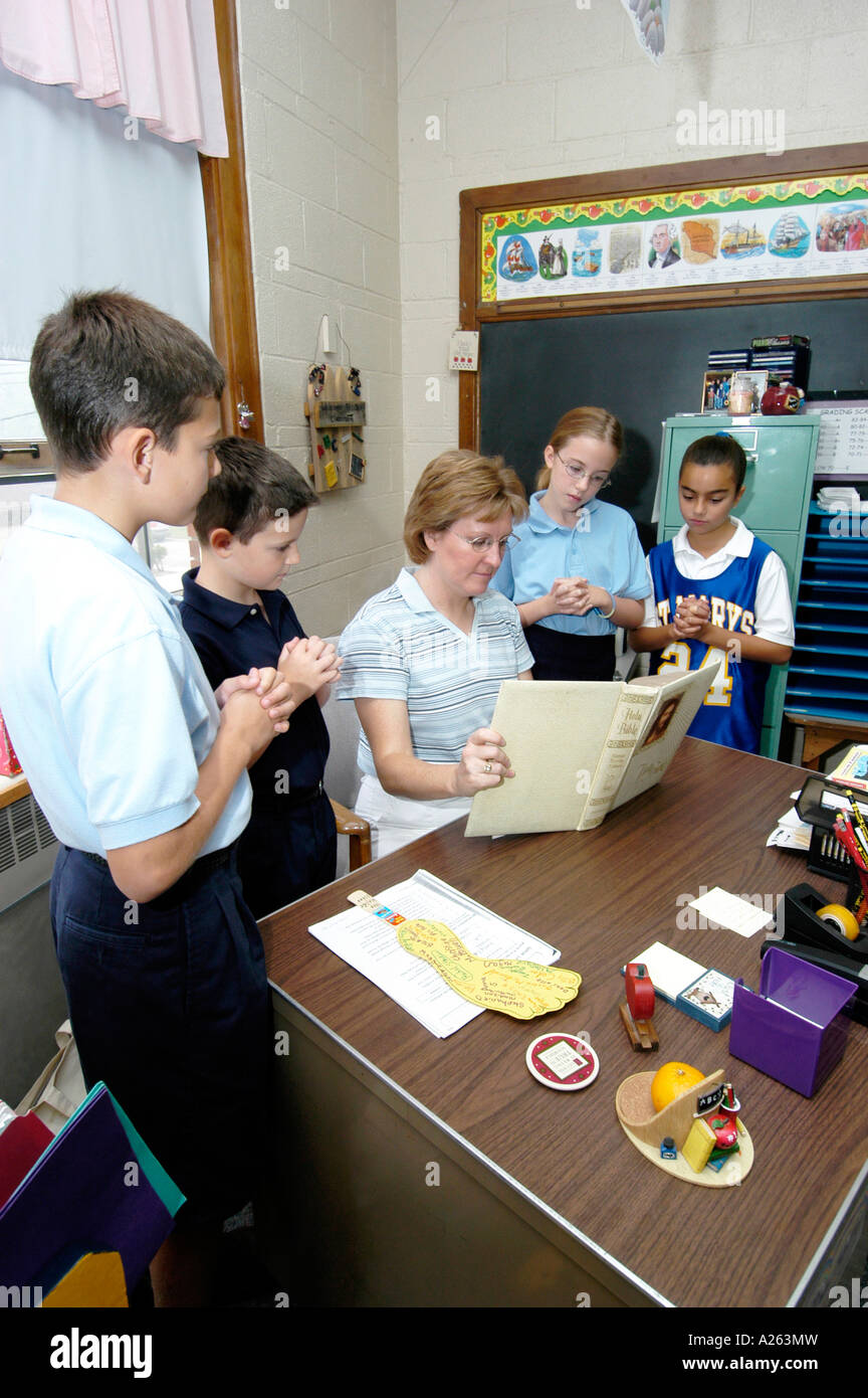 Students at teachers desk reading the bible Stock Photo - Alamy