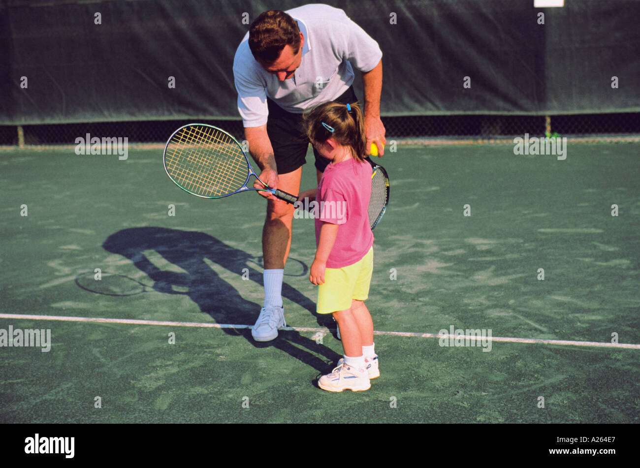 Trainer teaching to play tennis hi-res stock photography and images - Alamy