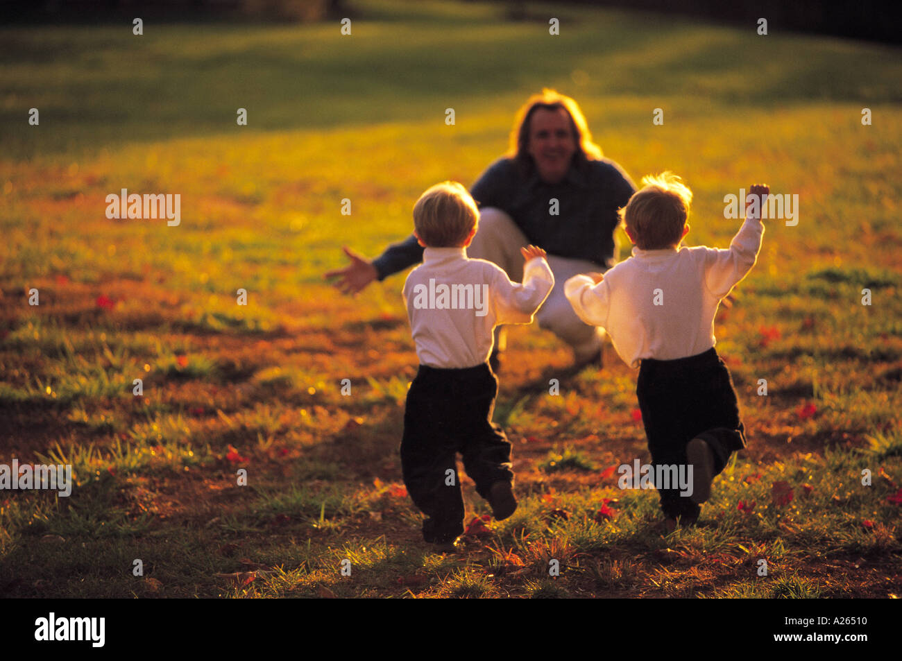 TWIN BOYS RUNNING TOWARDS THEIR FATHER Stock Photo - Alamy