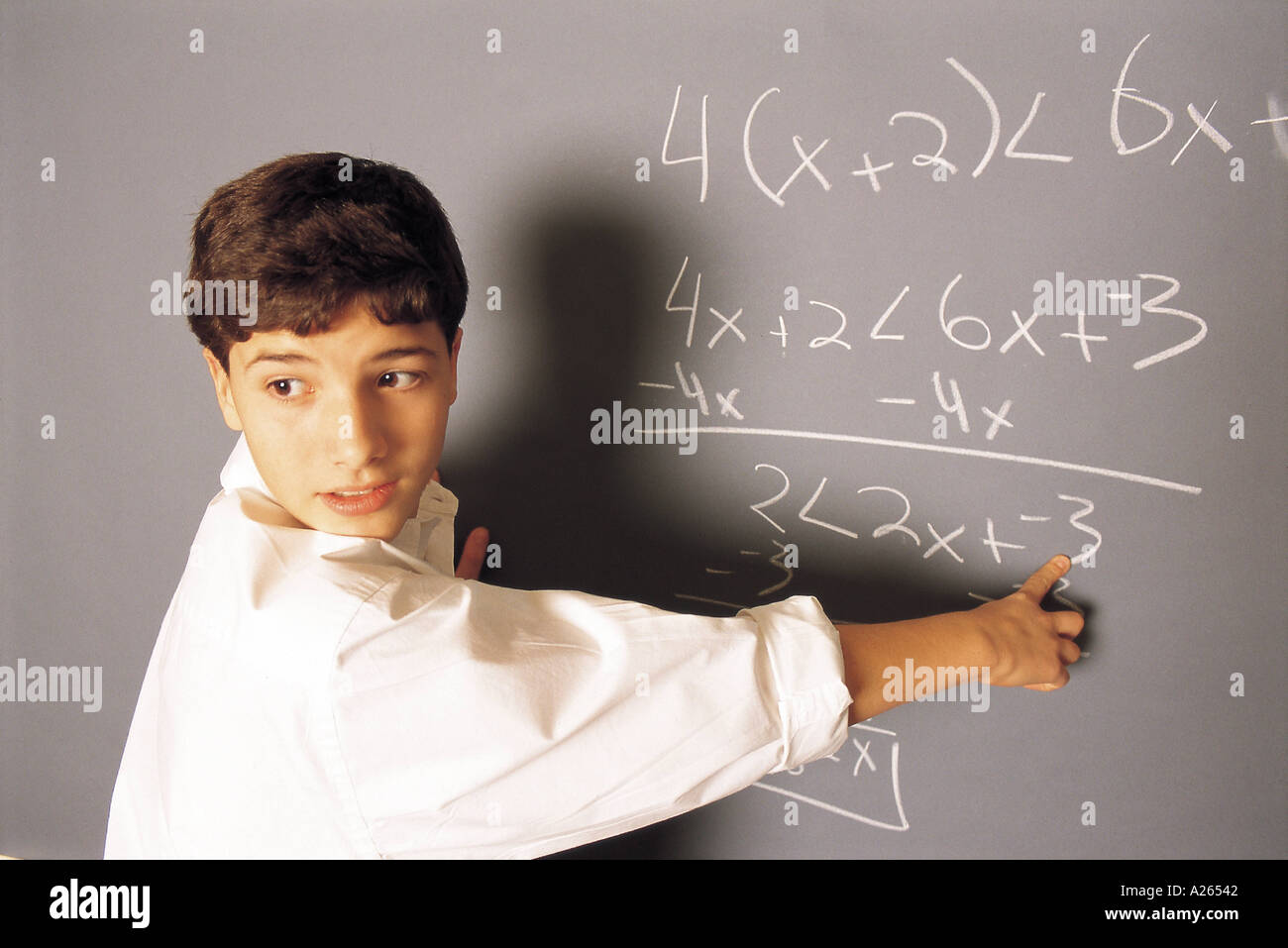 BOY POINTING TO NUMBERS OF MATHEMATICAL EQUATION ON BLACKBOARD Stock ...